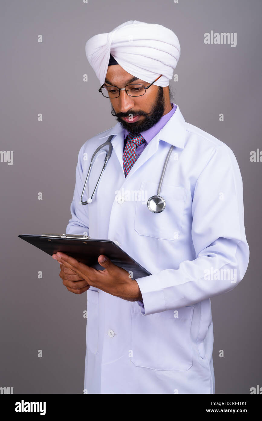 Portrait of young Indian Sikh man doctor holding clipboard Stock Photo ...