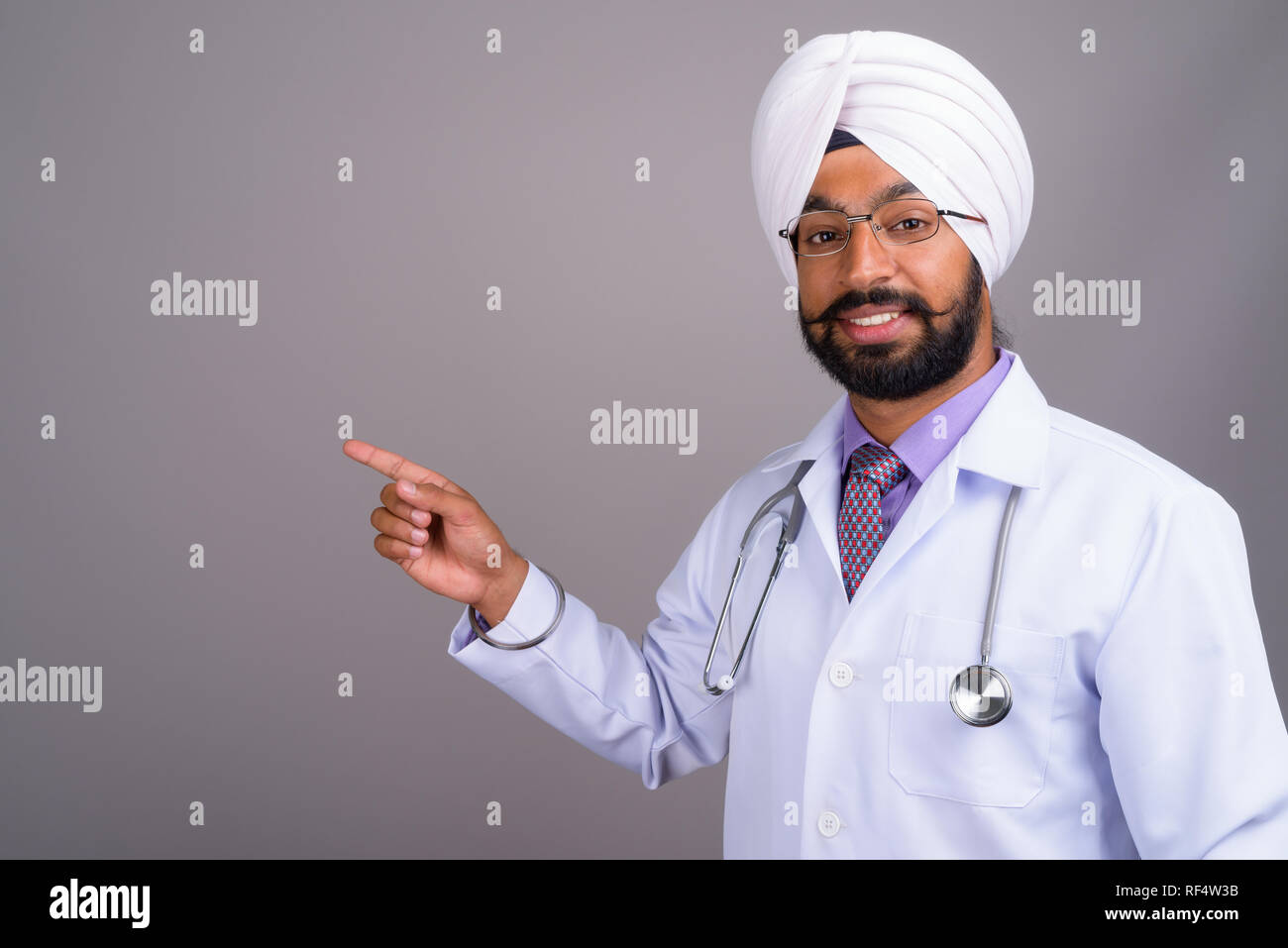 Portrait of young Indian Sikh man doctor smiling Stock Photo - Alamy
