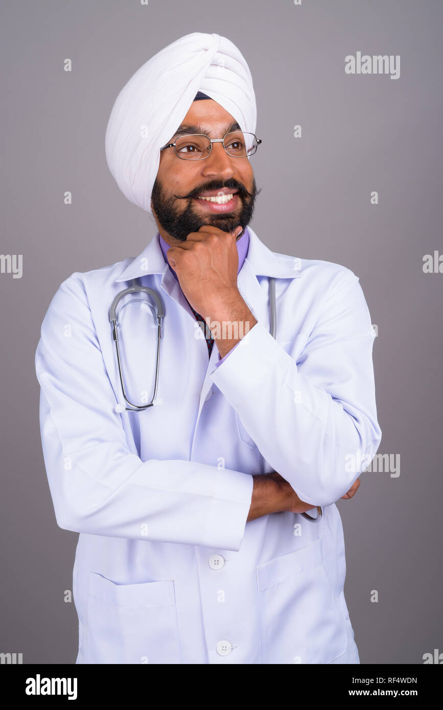 Indian Sikh man doctor thinking and smiling Stock Photo - Alamy