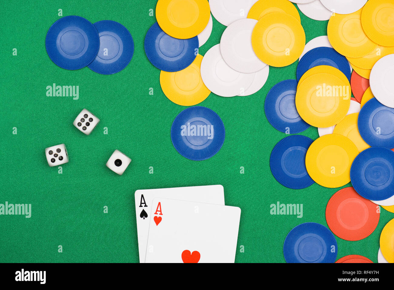top view of green poker table with multicolored chips, dices and two ...