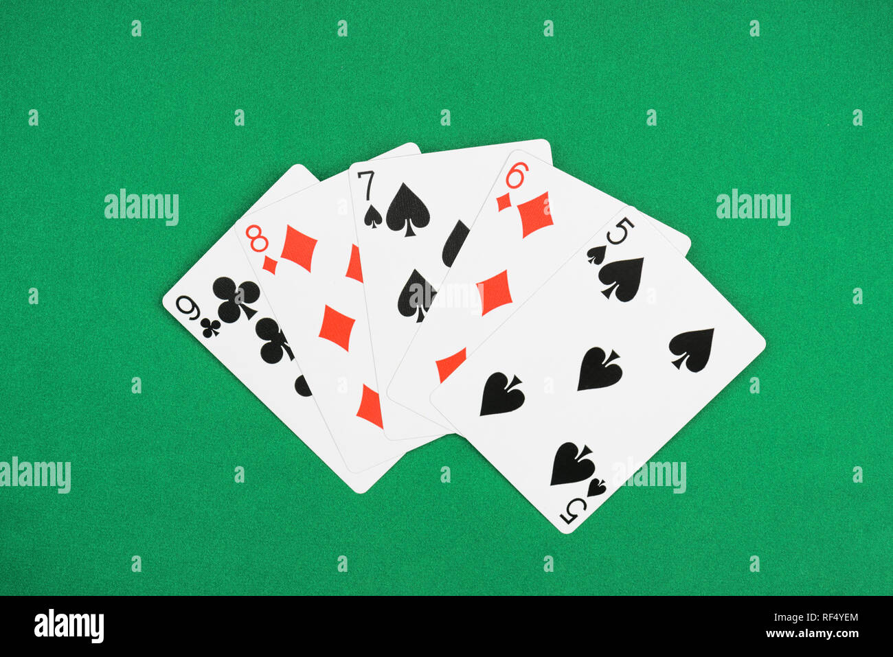 top view of green poker table and unfolded playing cards with different ...