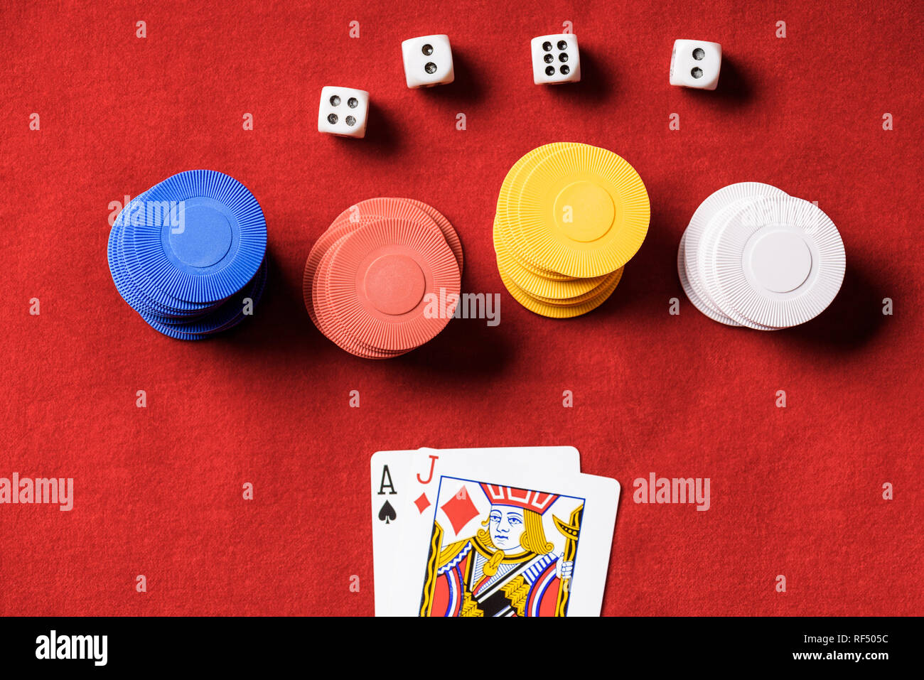 top view of red poker table with multicolored chips, dices and two ...