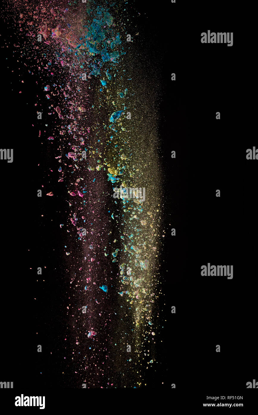 red, yellow and blue powder in air on black background Stock Photo - Alamy