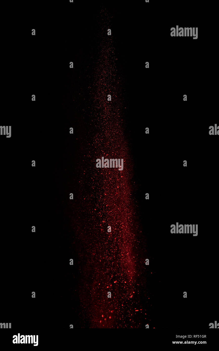 red powder in air and falling down on black background Stock Photo - Alamy