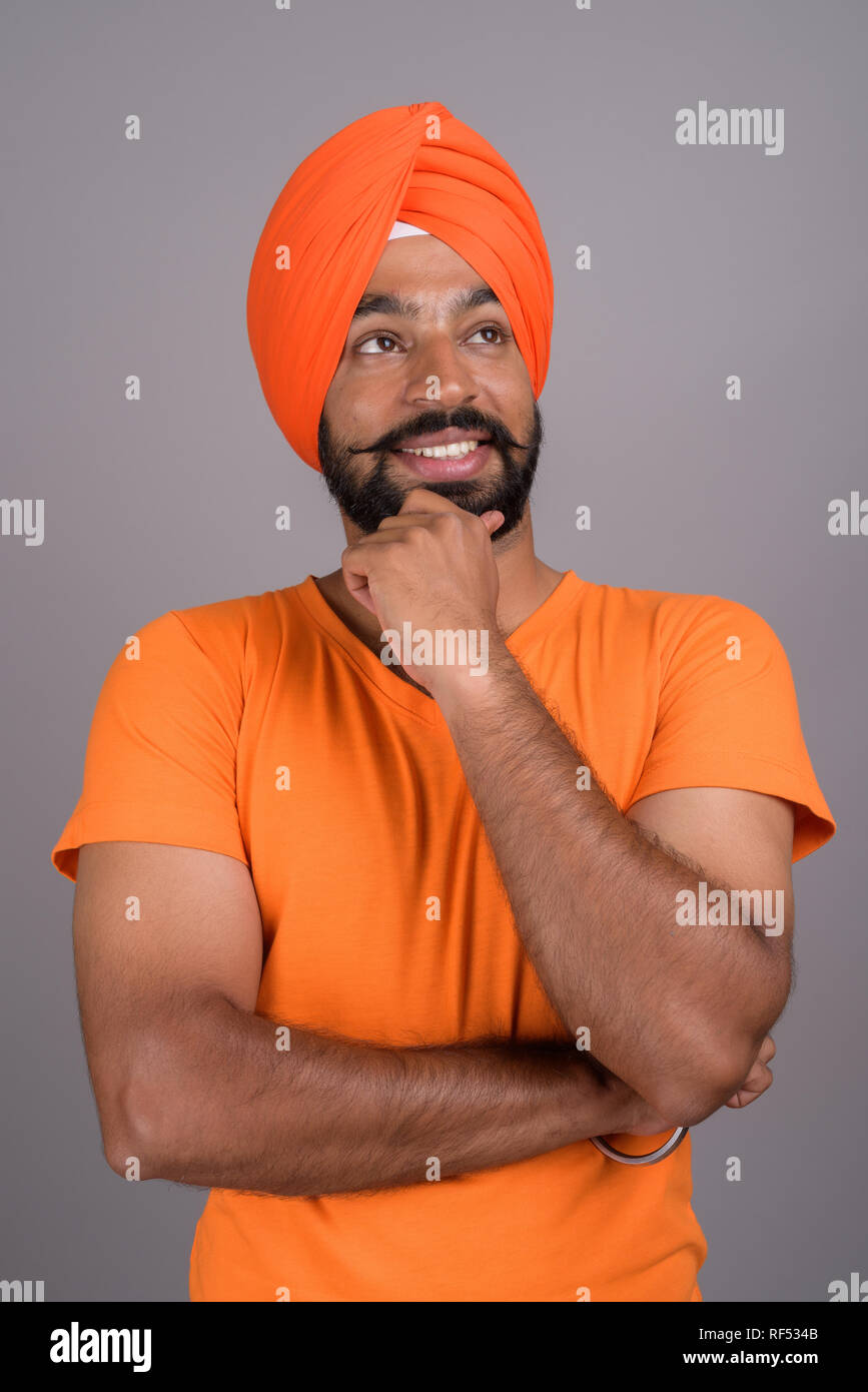 Indian Sikh man wearing turban and orange shirt Stock Photo - Alamy