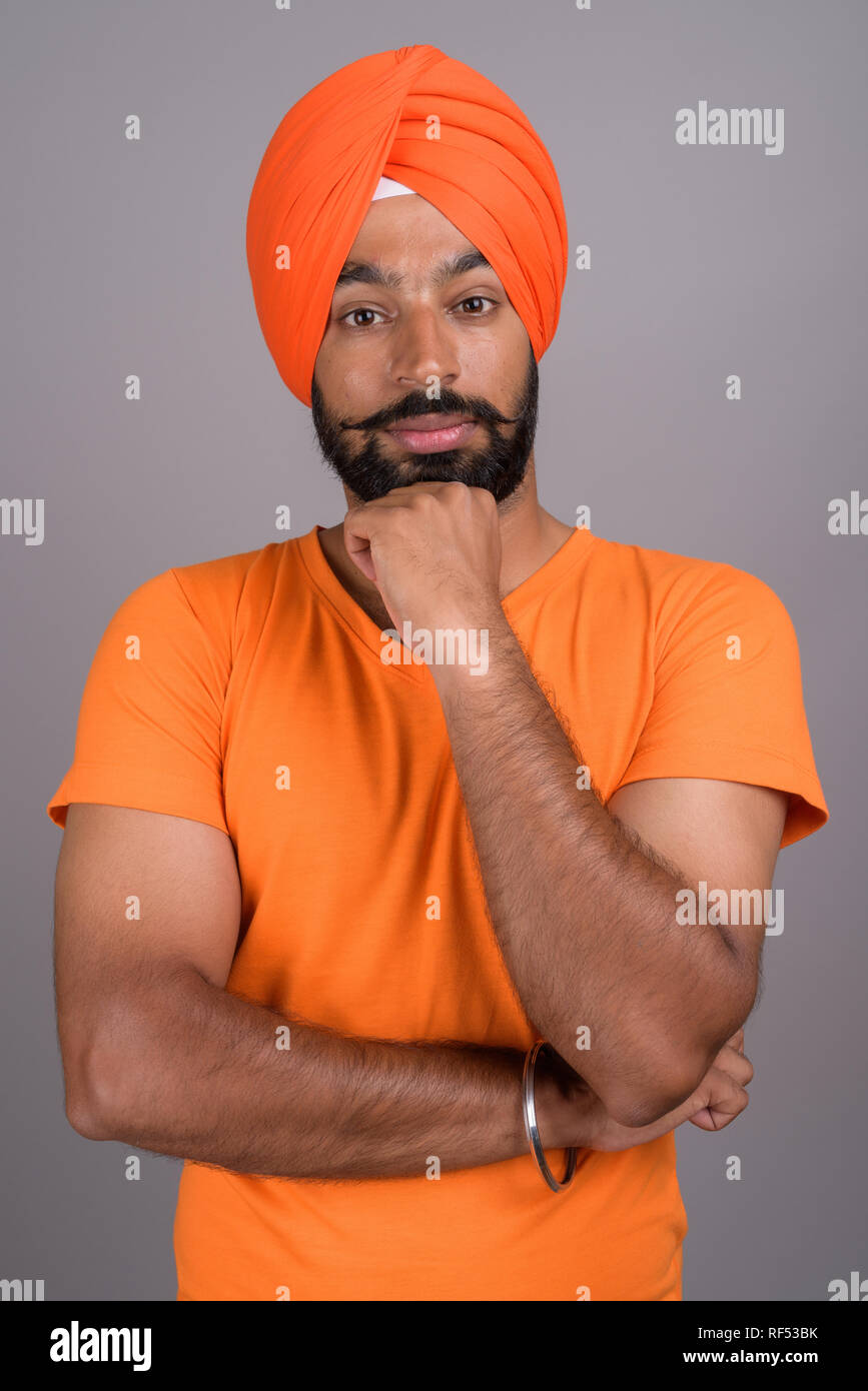 Indian Sikh man wearing turban and orange shirt Stock Photo - Alamy