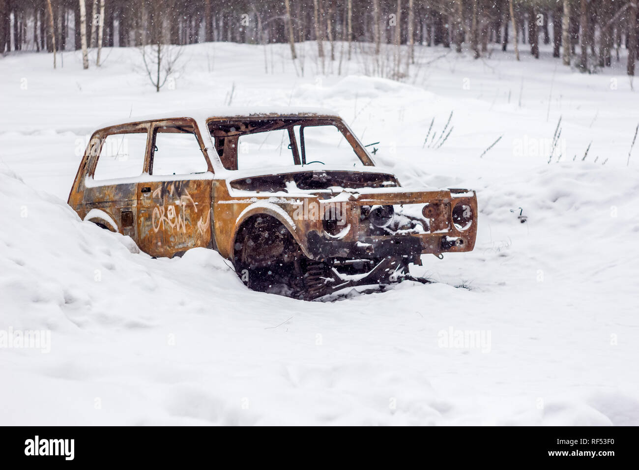 Old abandoned rusty car in snow in Russian winter forest under a tree Stock Photo - Alamy