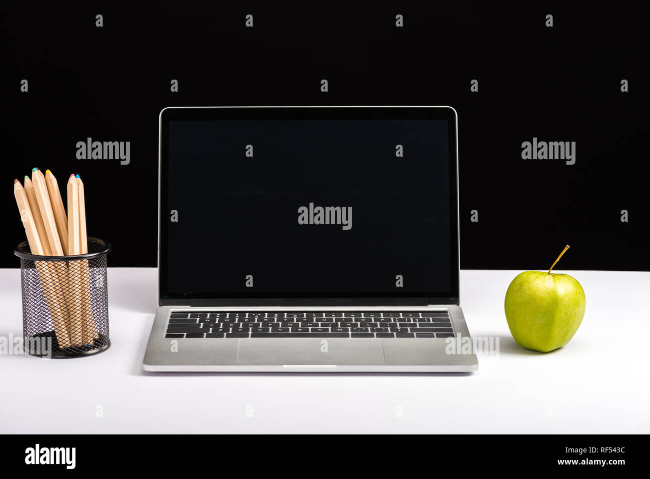 apple, laptop with blank screen and pencils isolated on black Stock ...