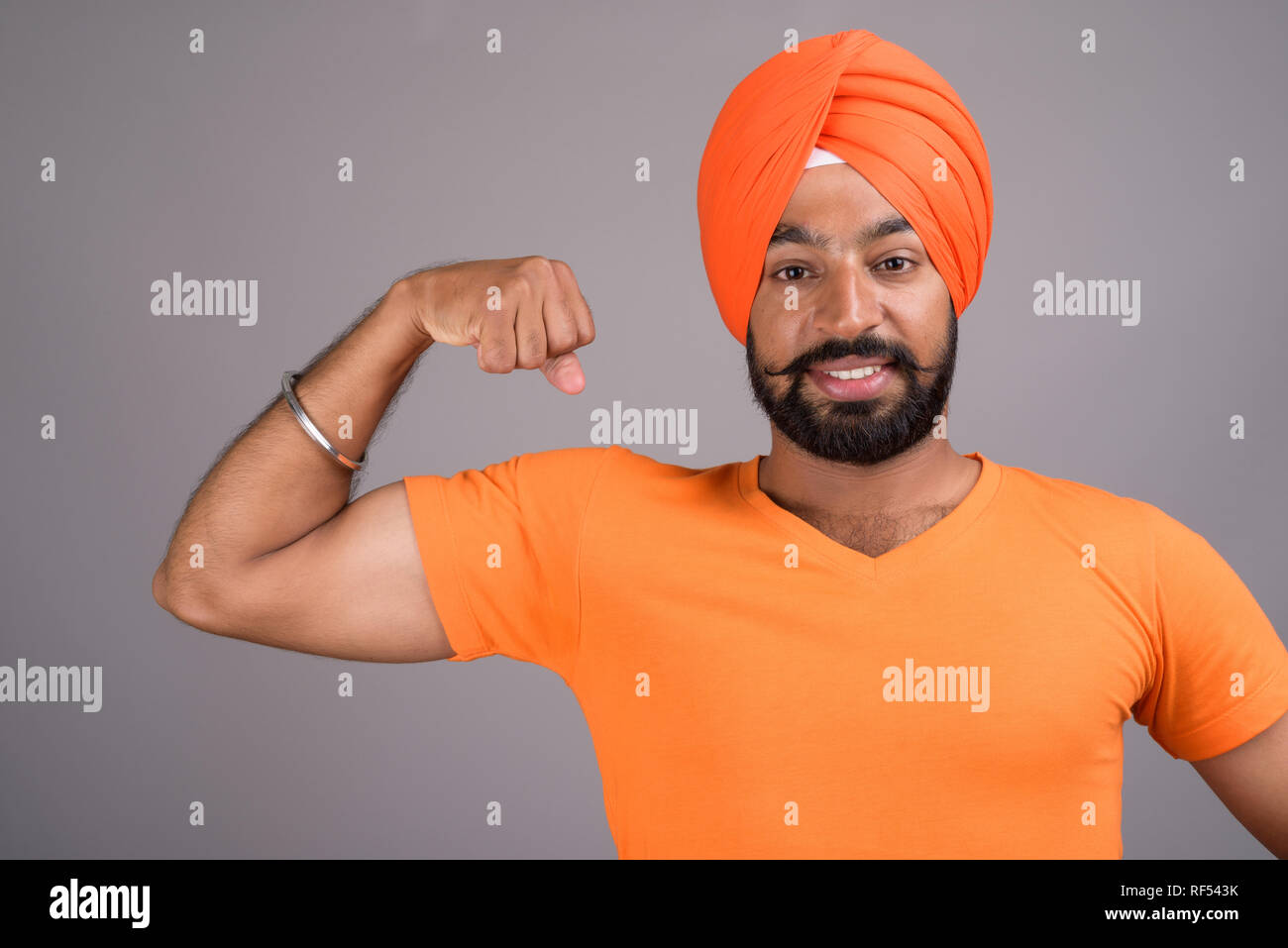 Indian Sikh man wearing turban and orange shirt Stock Photo - Alamy