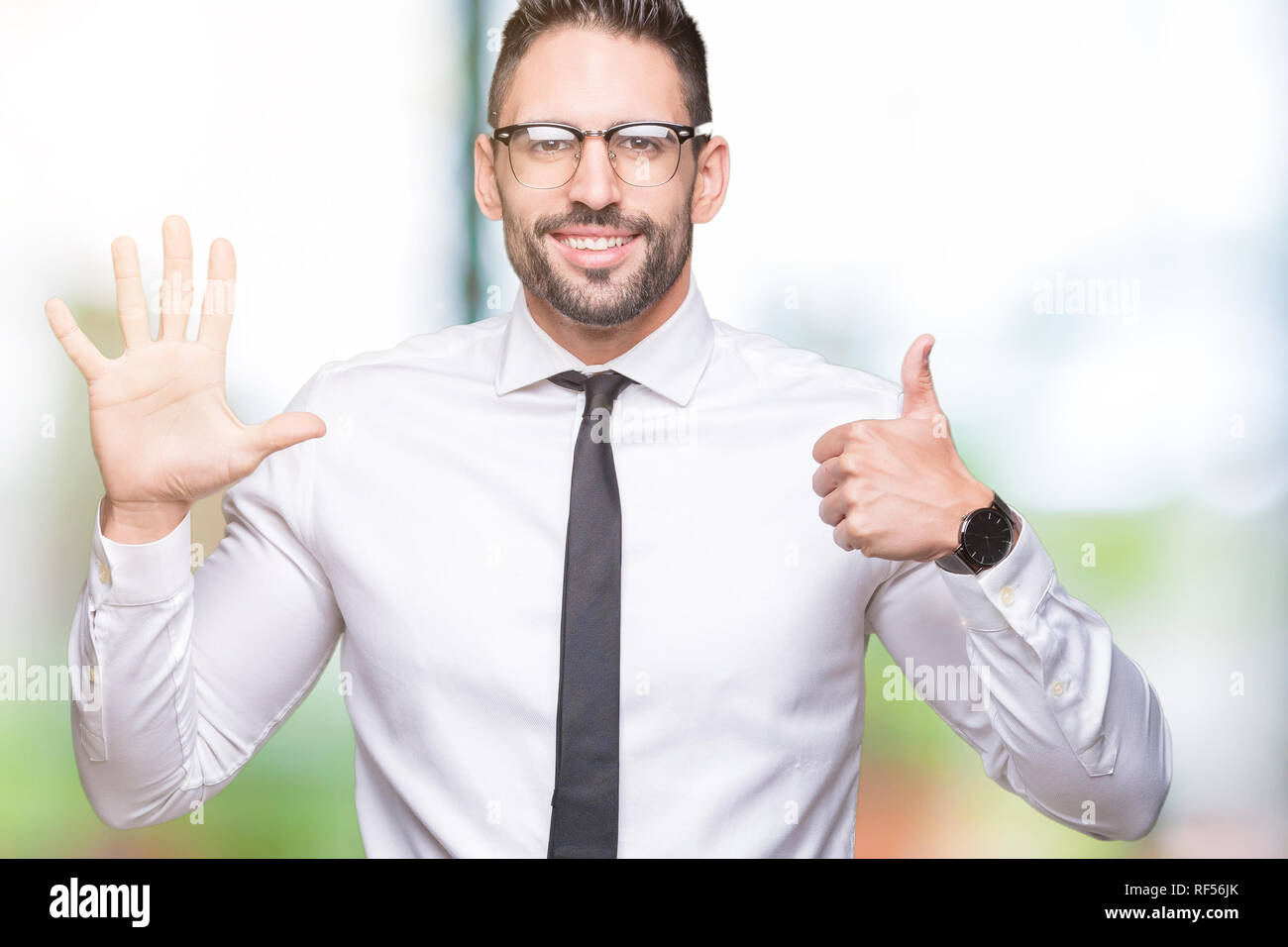 Young handsome business man wearing glasses over isolated background ...