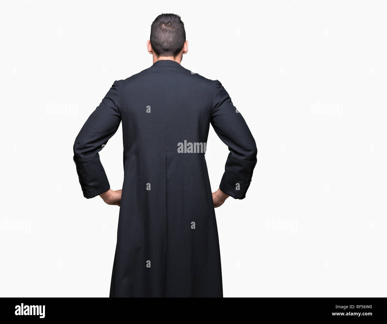 Young Christian priest over isolated background standing backwards ...