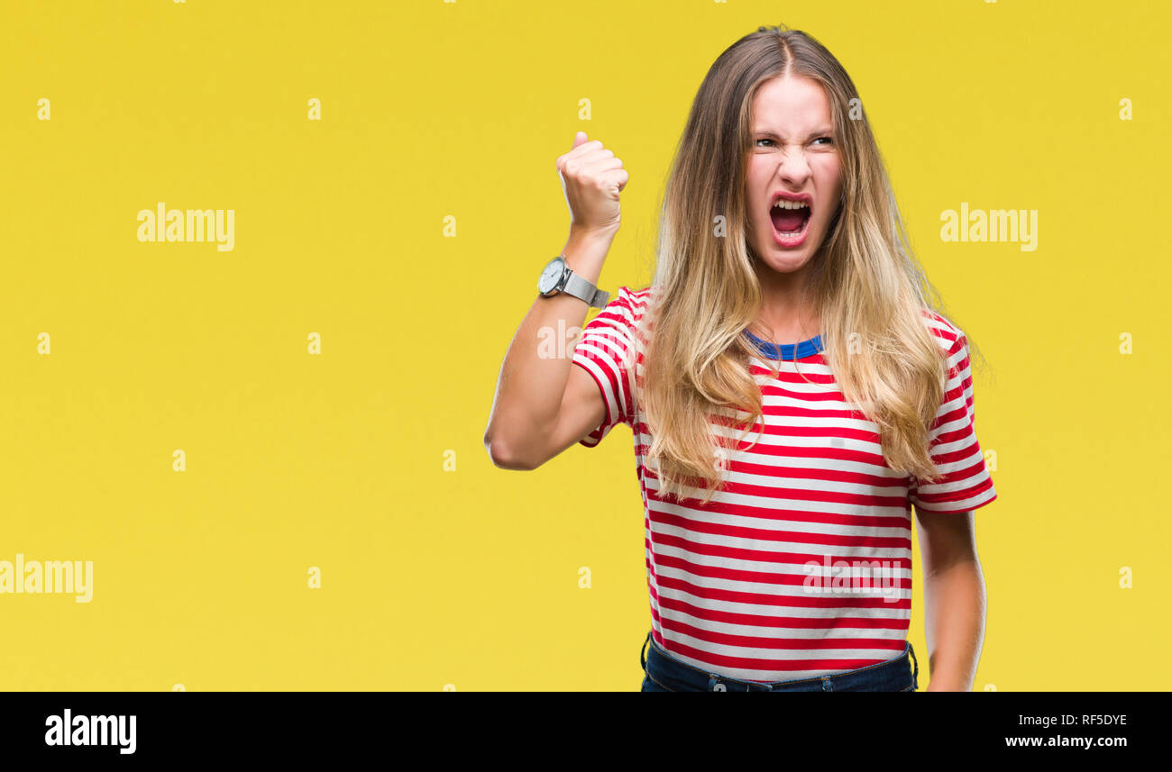 Young beautiful blonde woman over isolated background angry and mad ...