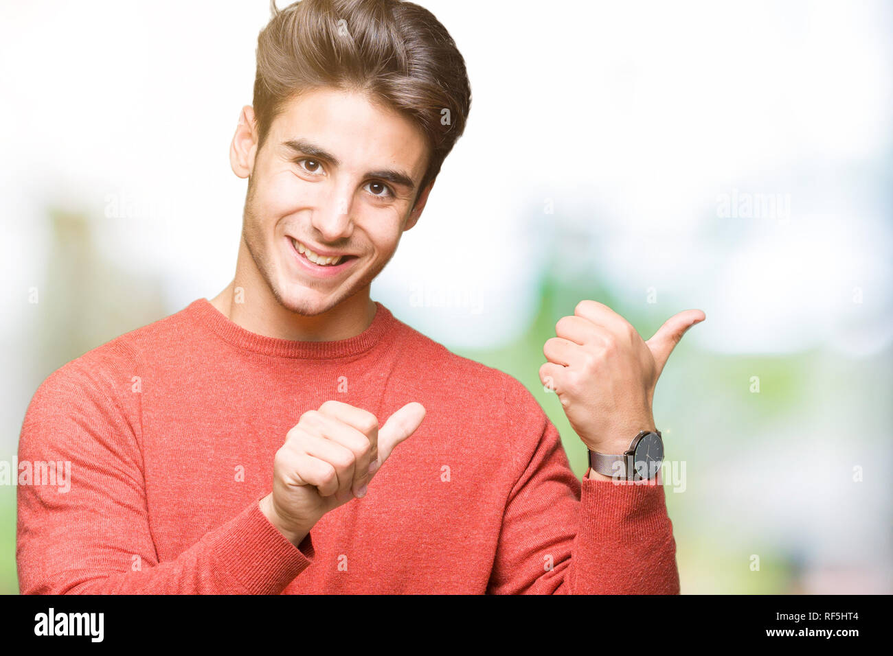 Young handsome man over isolated background Pointing to the back behind ...
