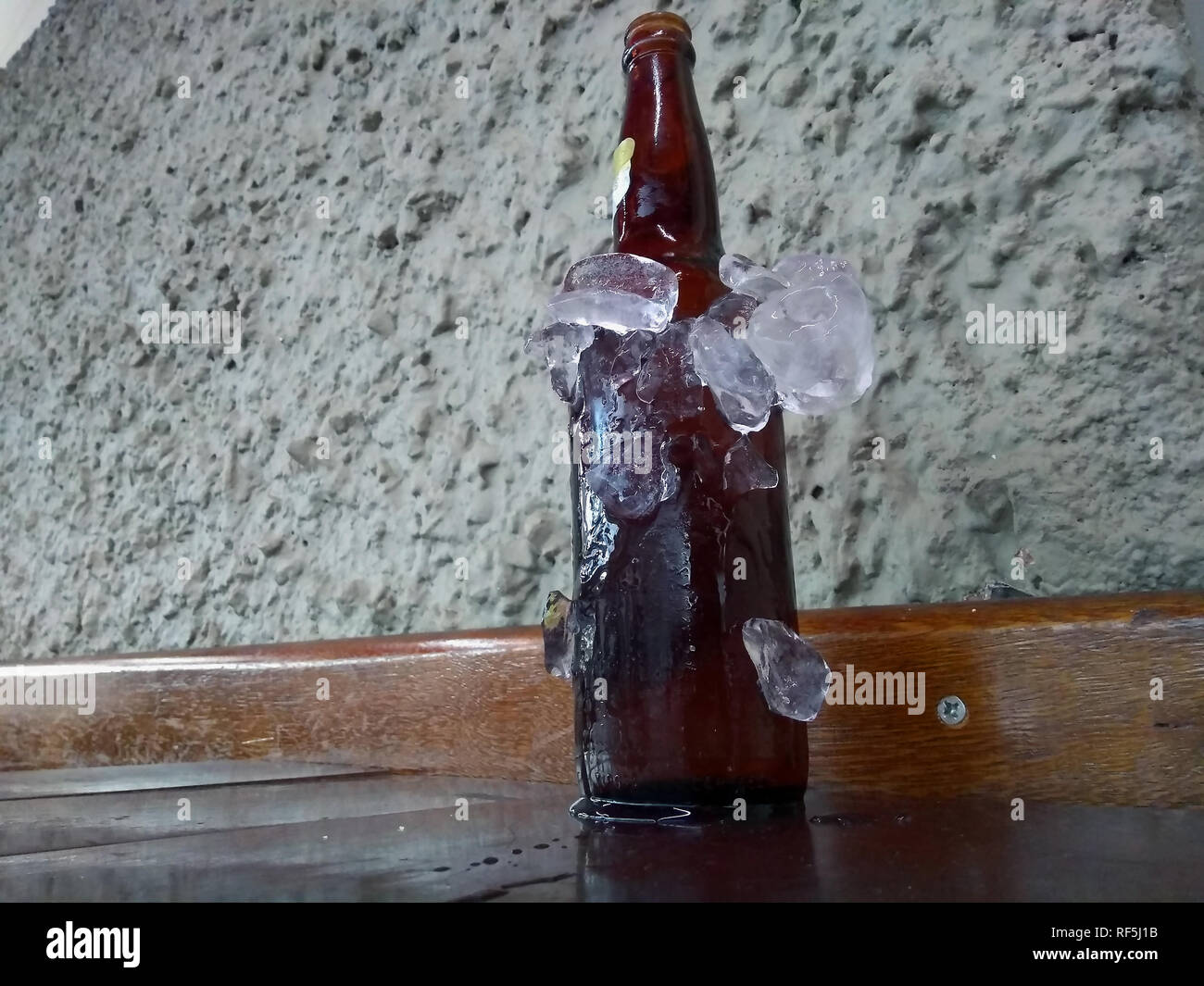 Beer bottles chilled in ice. The icy bottle of beer on wall background ...