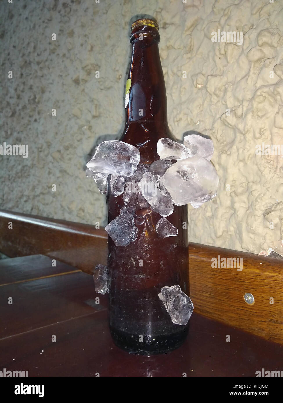 Beer bottles chilled in ice. The icy bottle of beer on wall background ...