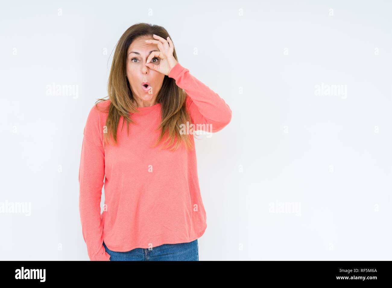 Beautiful middle age woman over isolated background doing ok gesture ...