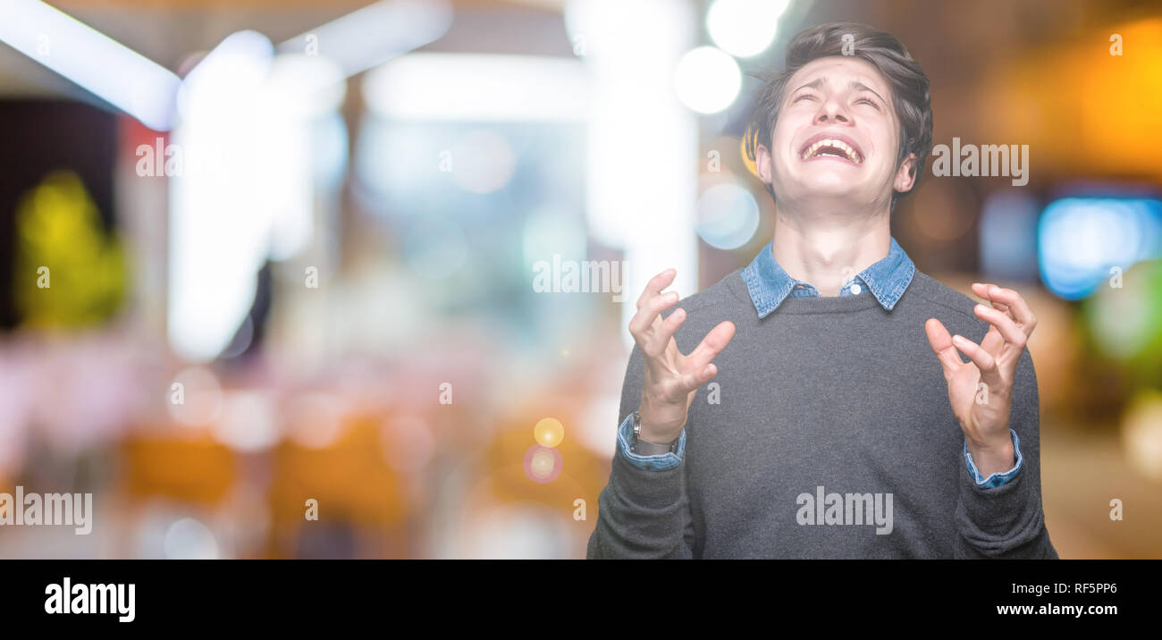 Young handsome elegant man over isolated background crazy and mad ...