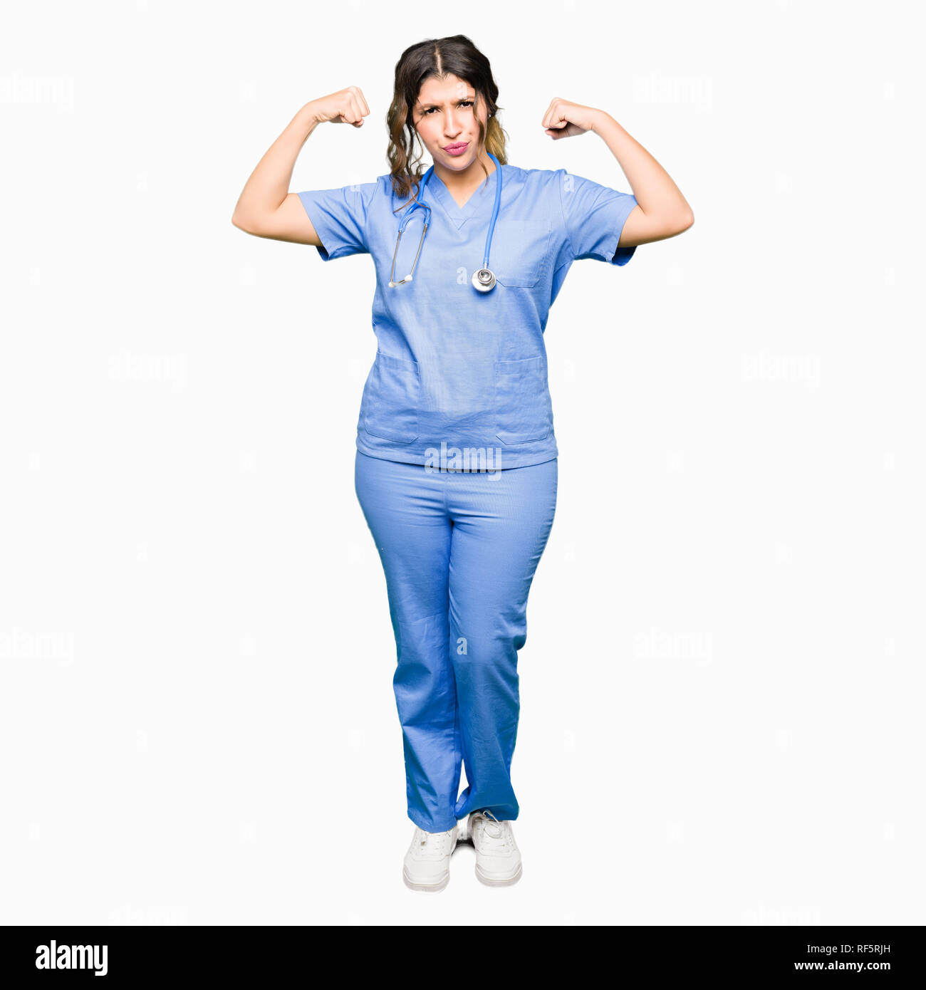 Young adult doctor woman wearing medical uniform showing arms muscles ...