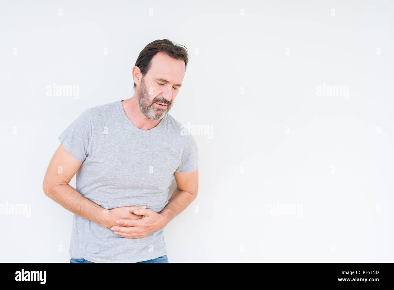 Handsome senior man over isolated background with hand on stomach ...
