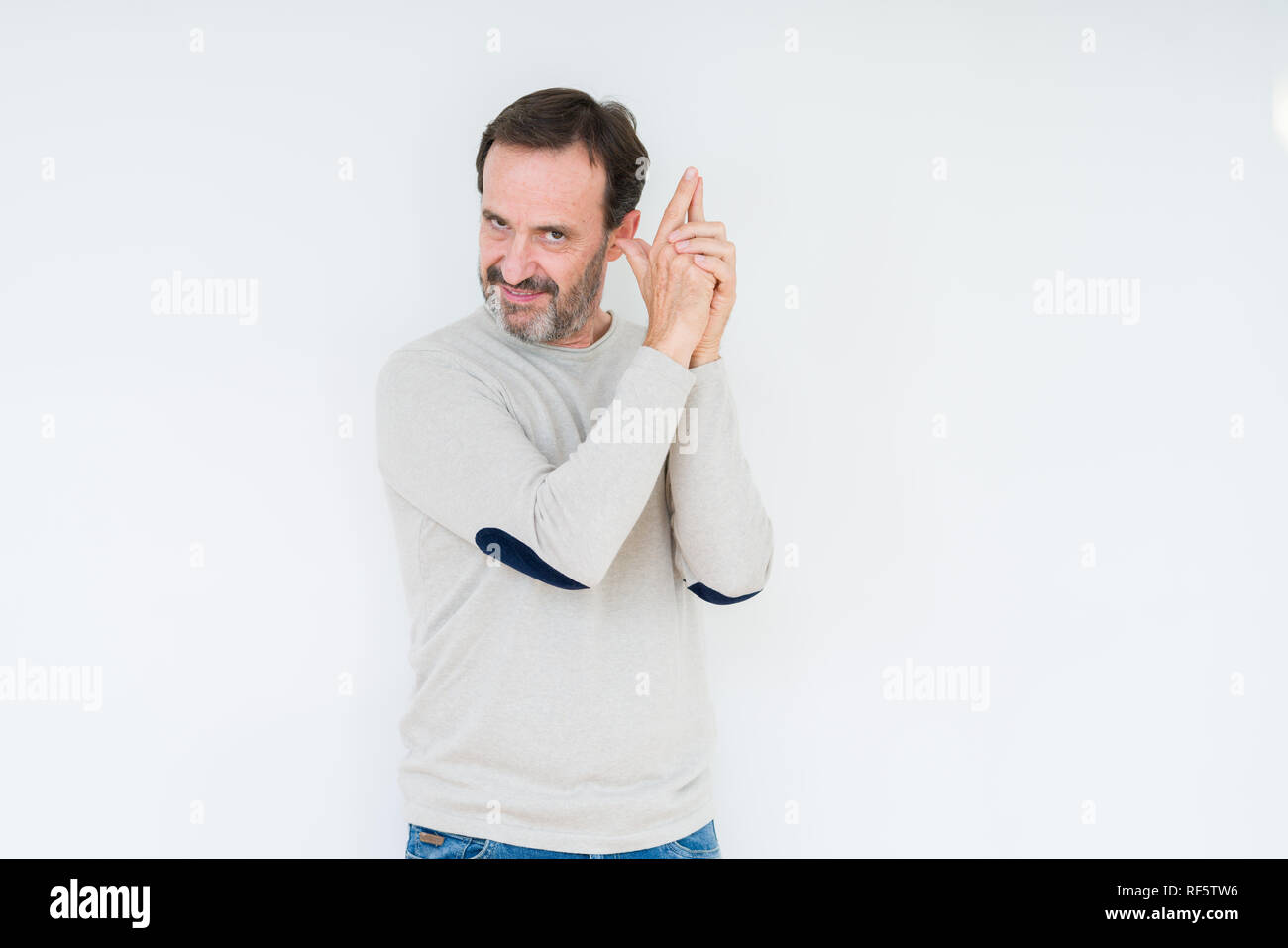 Elegant senior man over isolated background Holding symbolic gun with ...