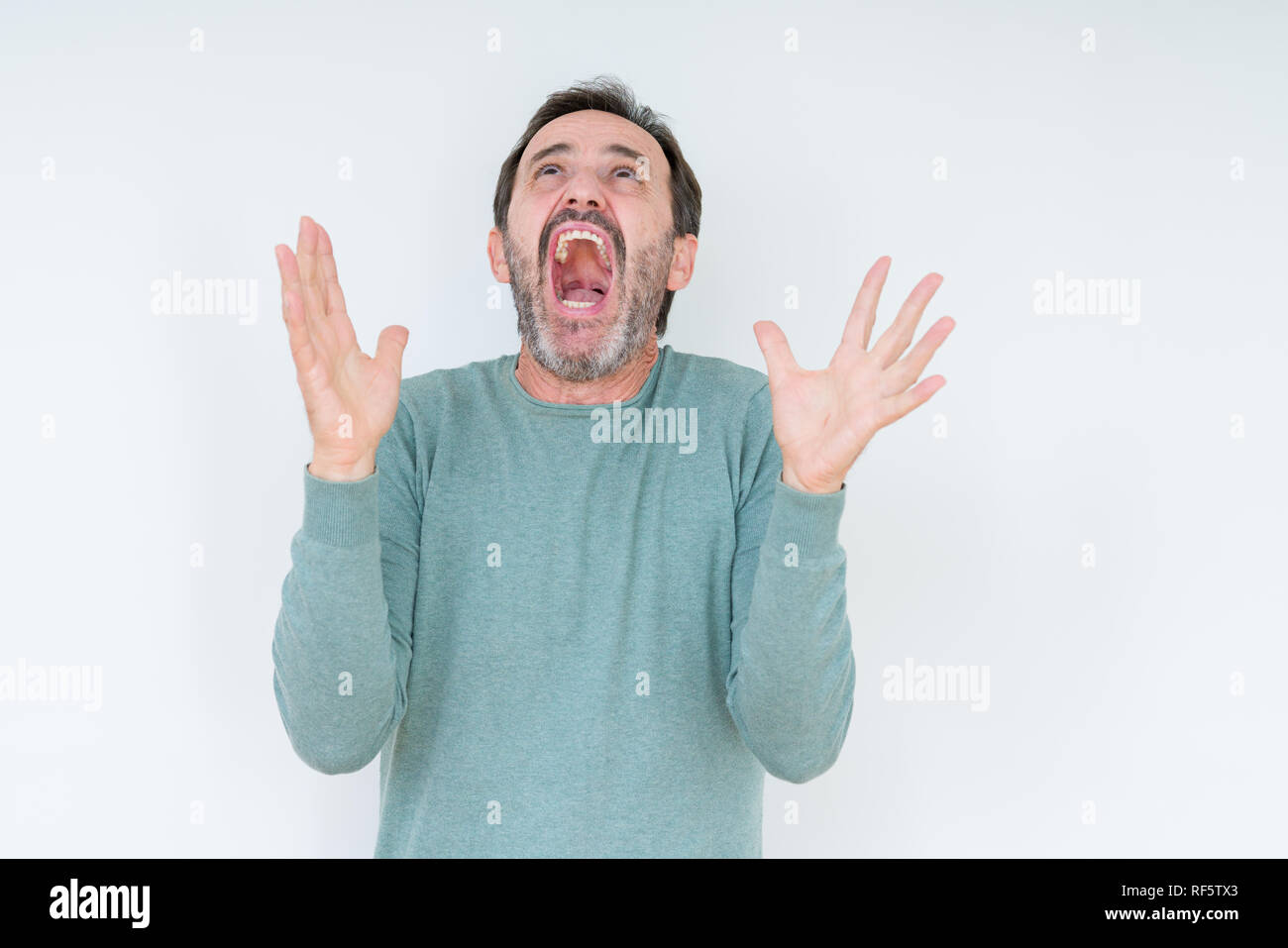 Senior man over isolated background crazy and mad shouting and yelling ...