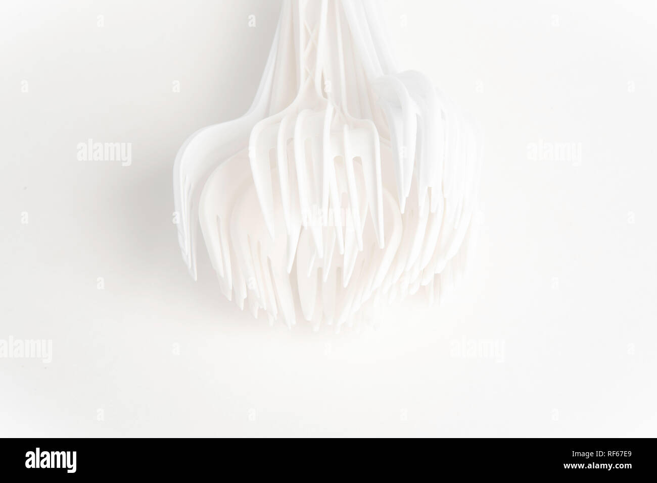 A bunch of white disposable single-use plastic forks commonly available ...