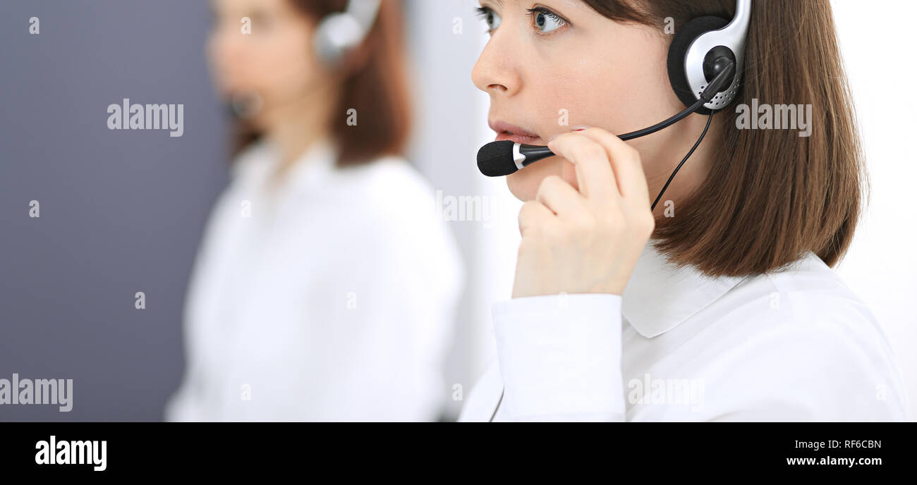 Call center. Group of operators at work. Focus on young brunette woman. Business concept Stock ...
