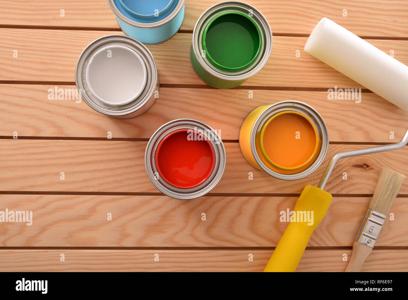 Colorful paint pots open on wood table for renovation of materials and ...