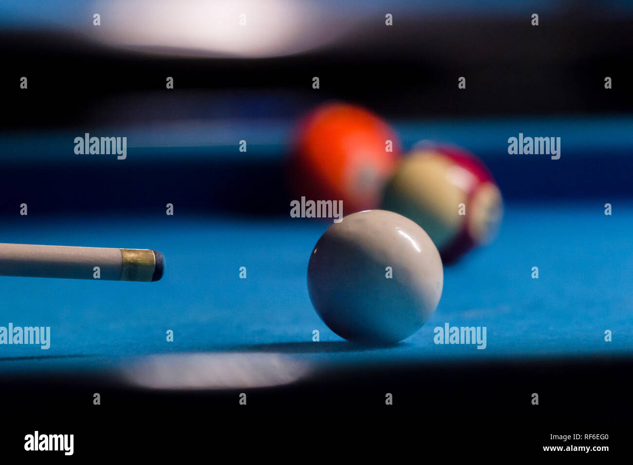 Playing billiard. Billiards balls and cue on blue billiards table Stock ...