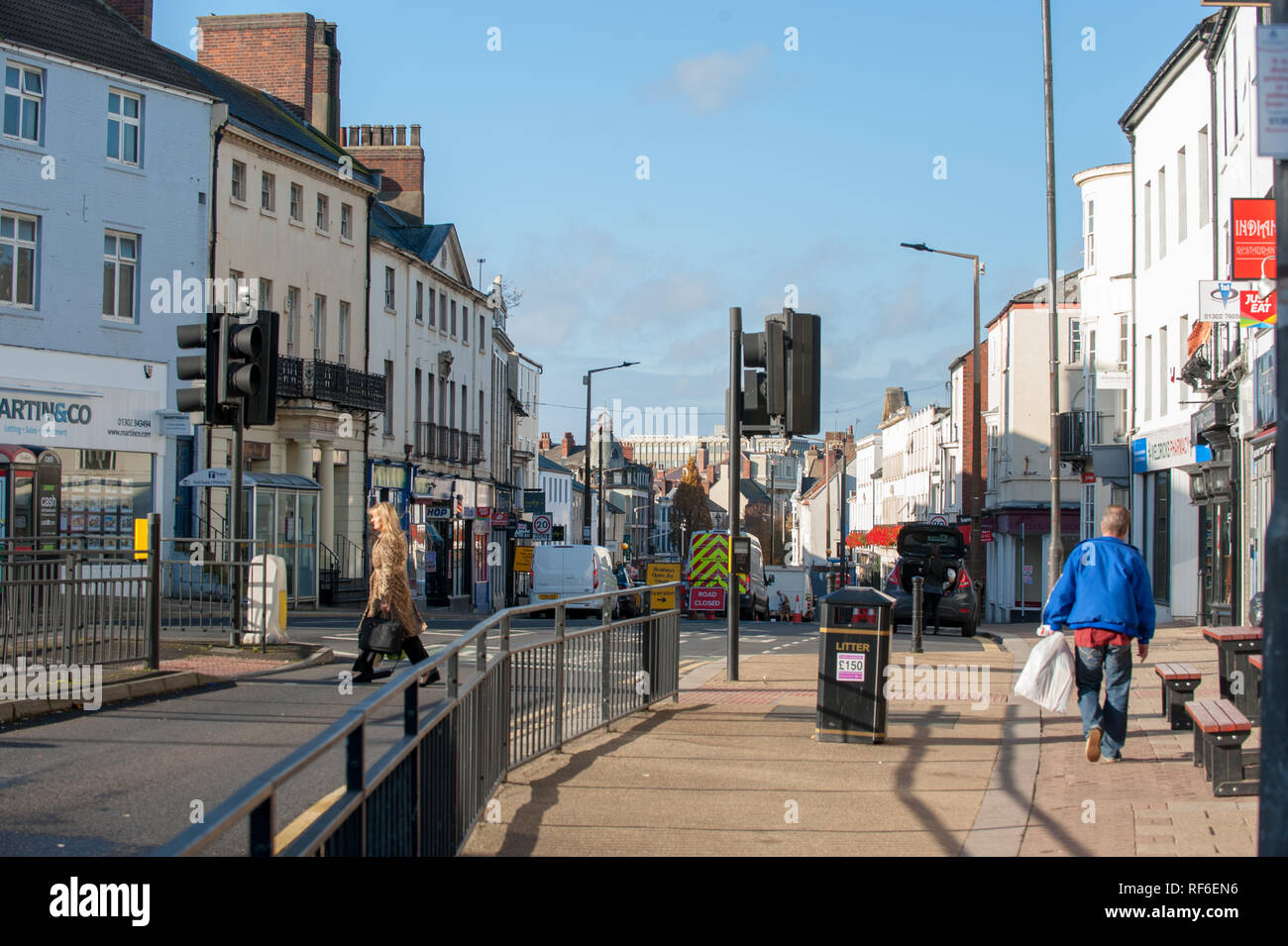 a sunny urban street scene in Doncaster, UK, featuring pedestrians ...