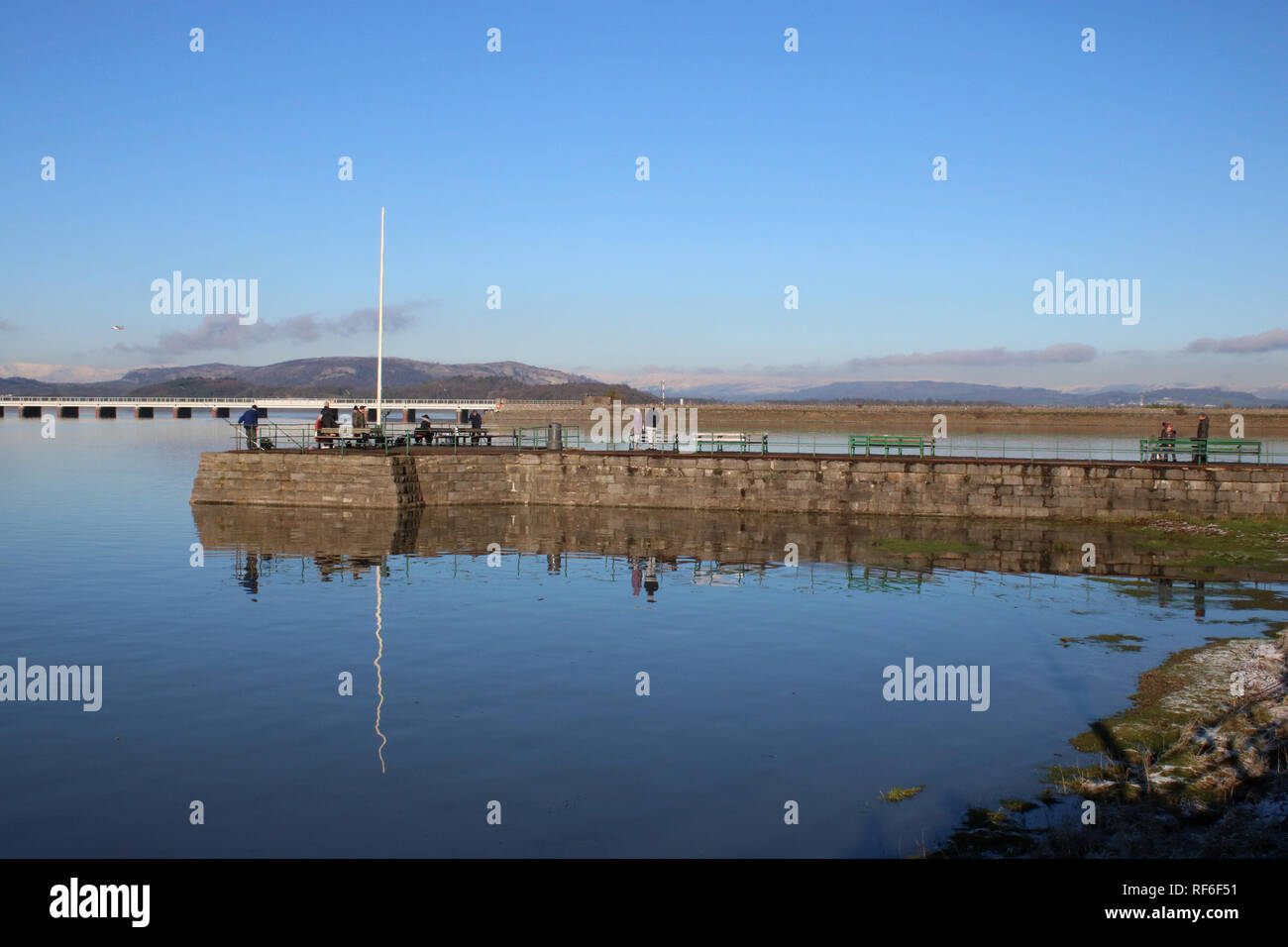 People fishing in the River Kent estuary from Arnside Pier at high tide ...