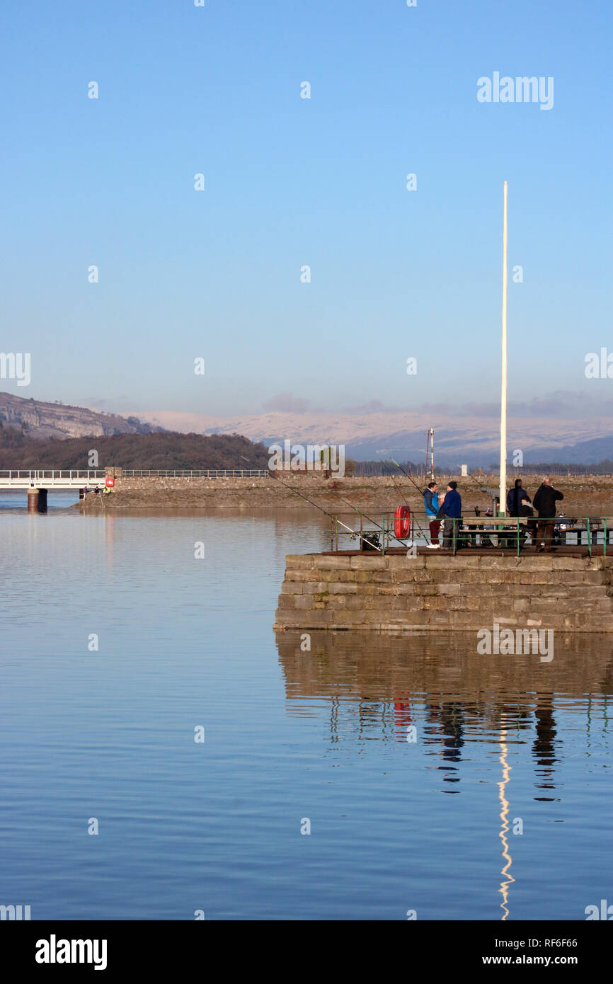 People fishing in the River Kent estuary from Arnside Pier at high tide ...
