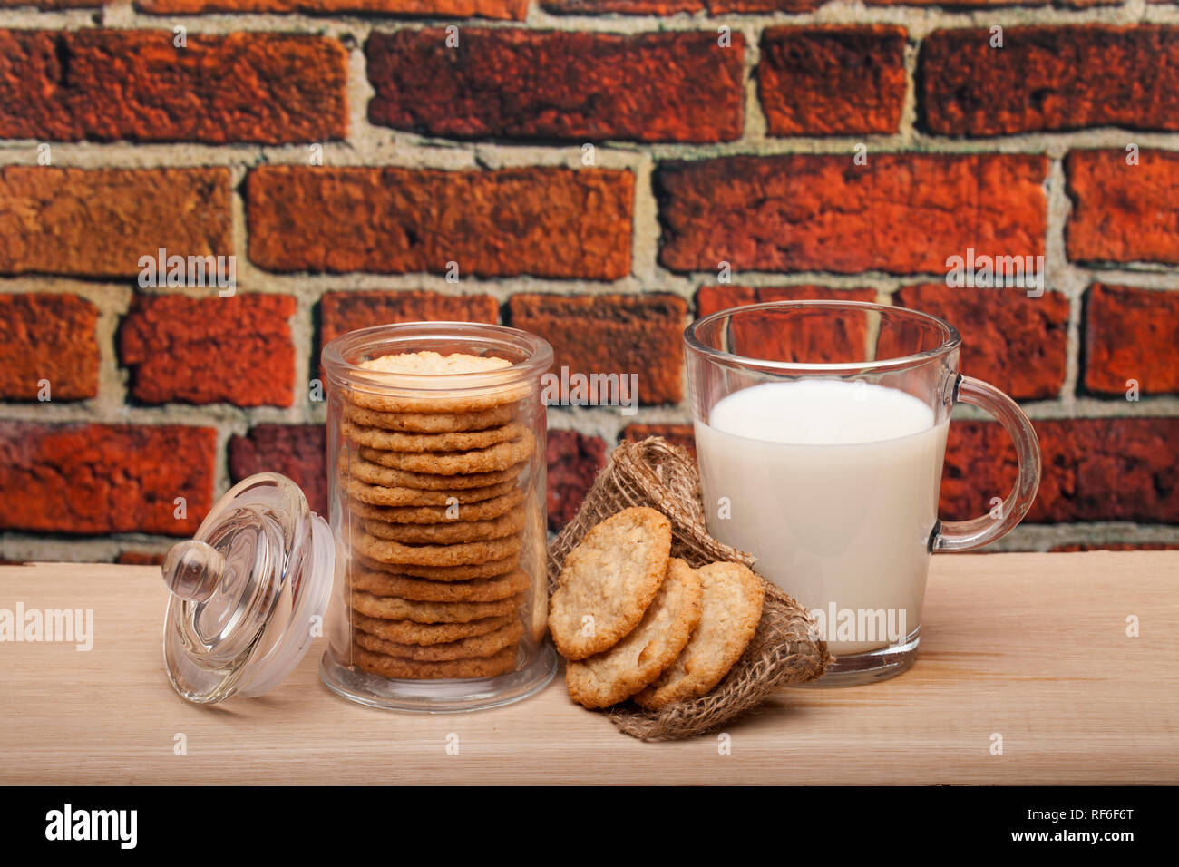 Oatmeal cookies with milk on the oak table, with brick wall Stock Photo ...