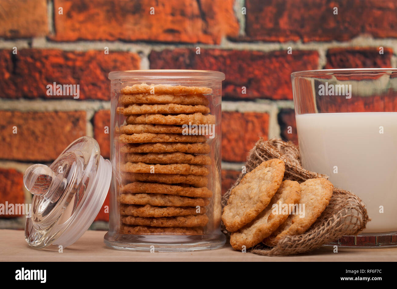 Oatmeal cookies with milk on the oak table, with brick wall Stock Photo ...