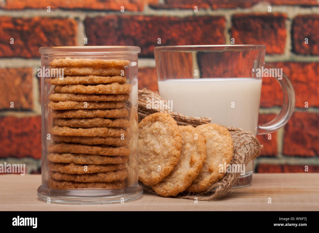 Oatmeal cookies with milk on the oak table, with brick wall Stock Photo ...