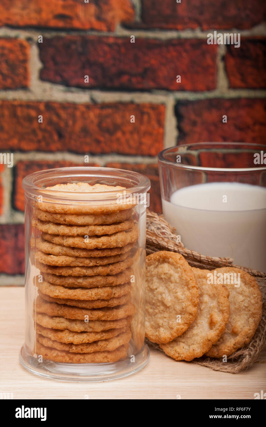 Oatmeal cookies with milk on the oak table, with brick wall Stock Photo ...