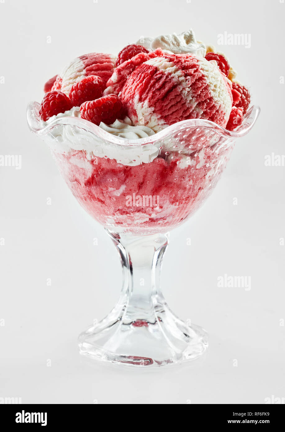 Raspberry and vanilla ice cream sundae with fresh fruit and whipped ...