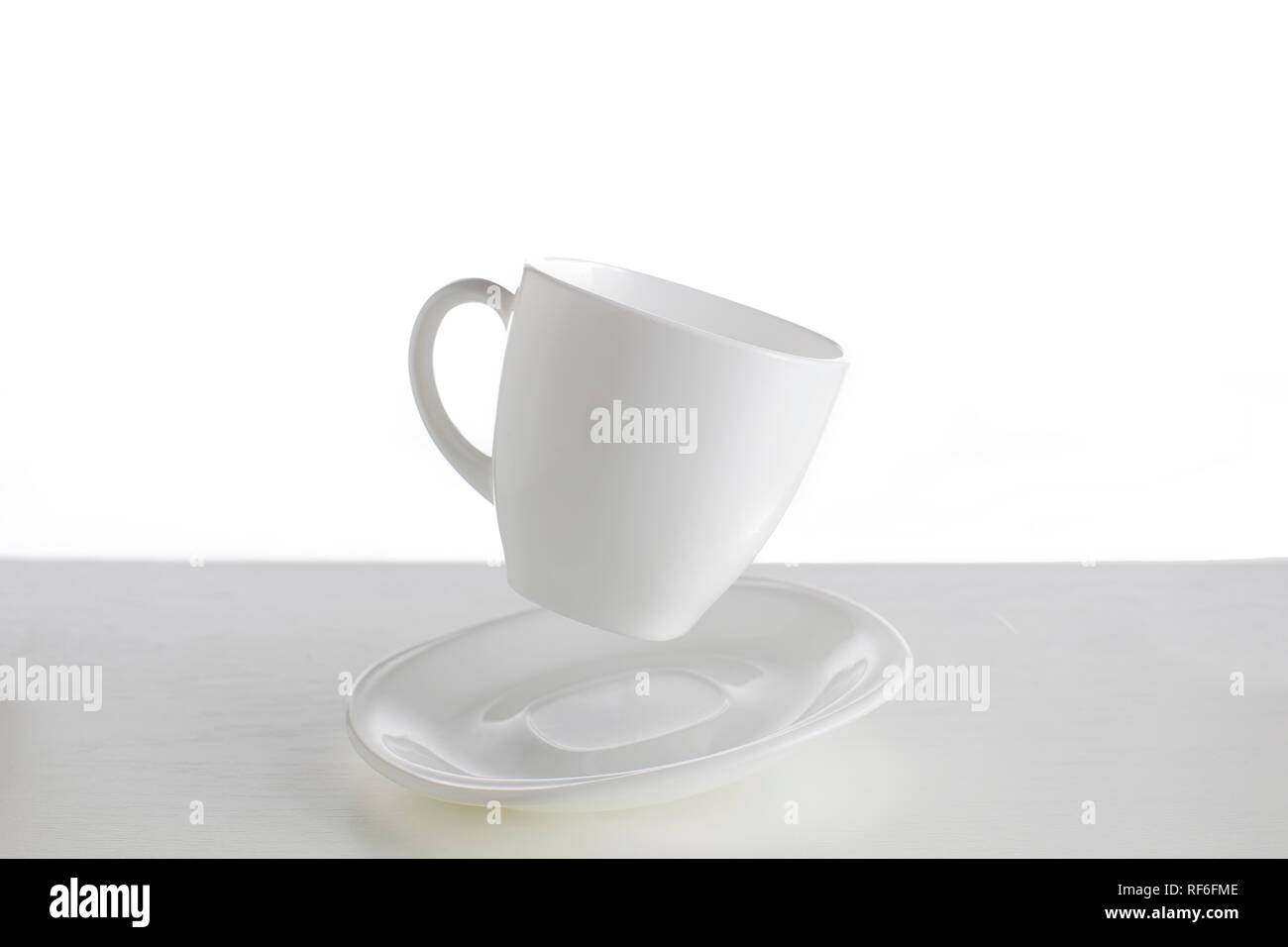 White cup with saucer in a jump on a white background. Jumping cup ...