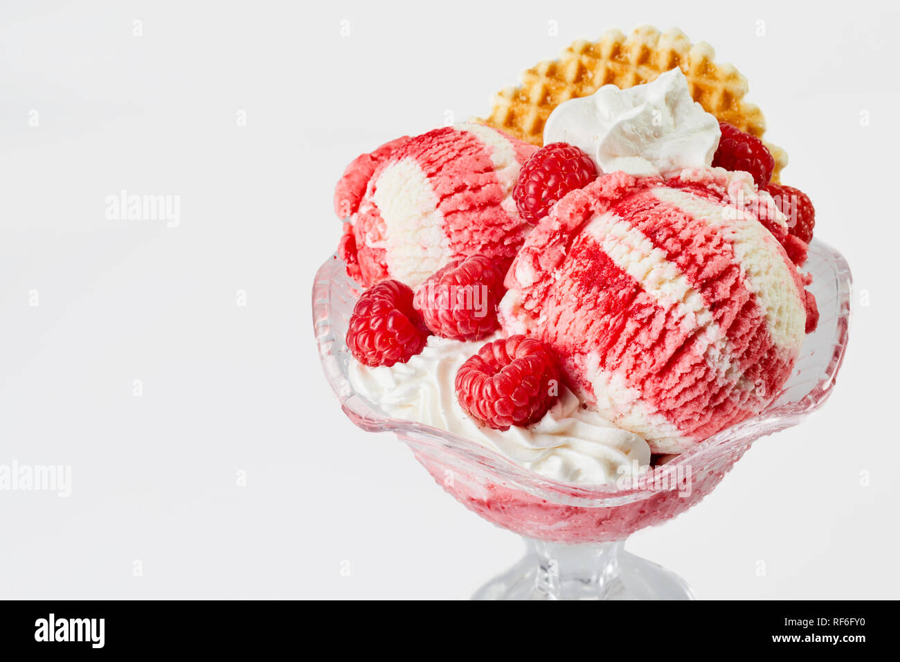 Scoops of delicious creamy vanilla and raspberry ice cream served in a ...