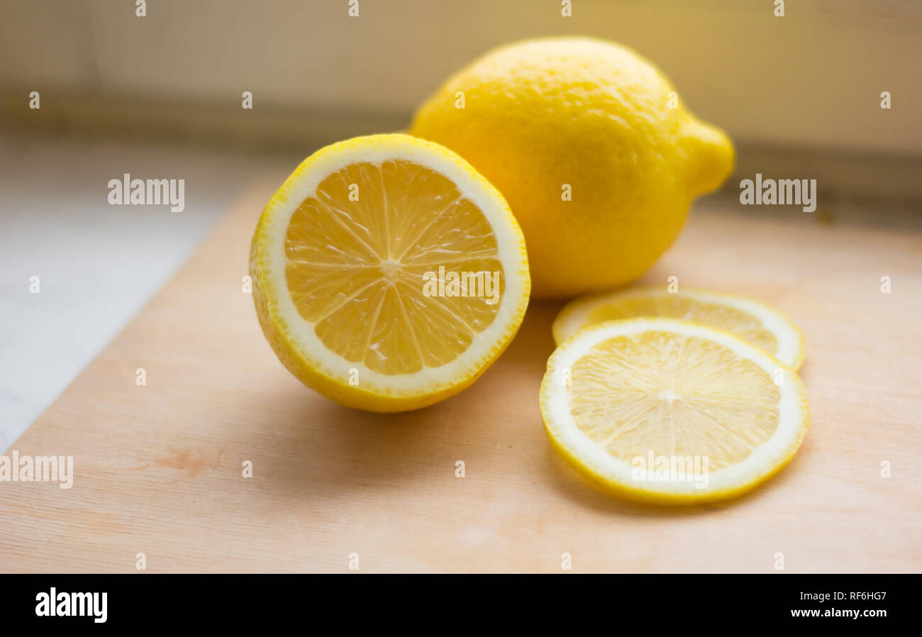 Sliced lemon on a wooden board. Fruits are chopped. Sour lemon. Citrus ...