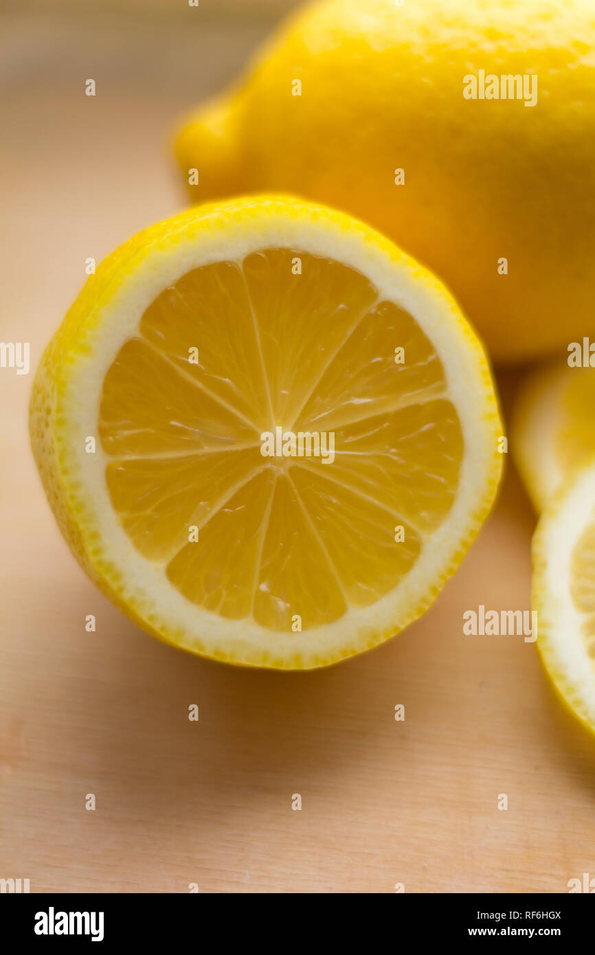 Sliced lemon on a wooden board. Fruits are chopped. Sour lemon. Citrus ...