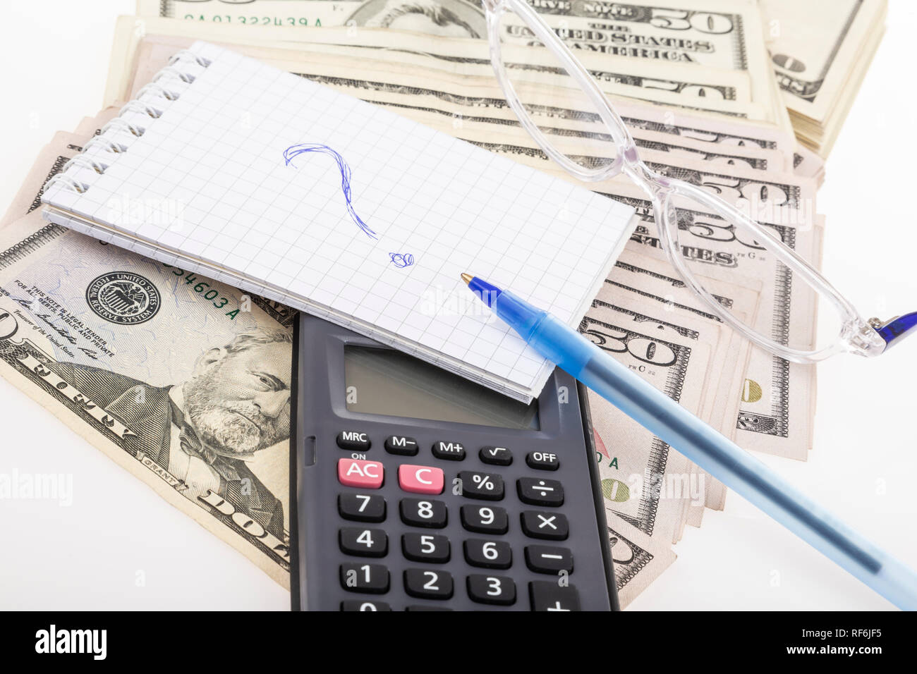 A calculator and notebook with question mark on background with ...