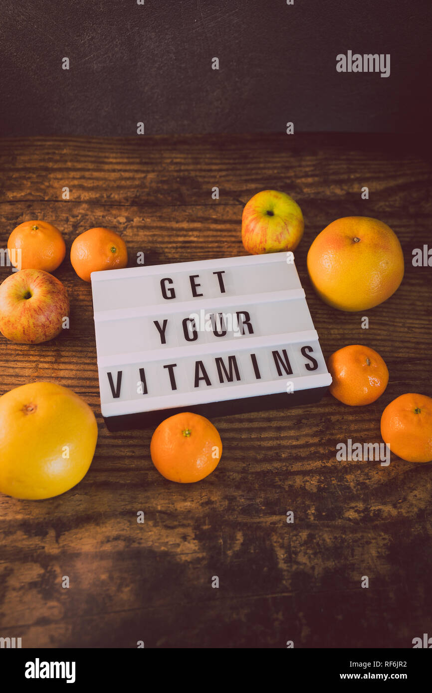 get your vitamins concept: lightbox with message surrounded by healthy ...