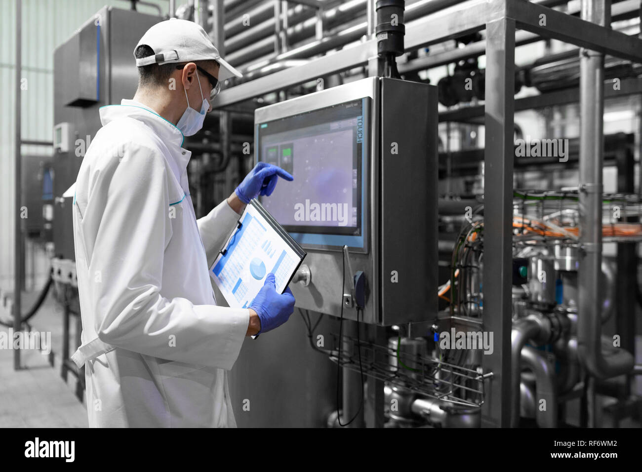 technologist taking necessary notes while standing at production ...