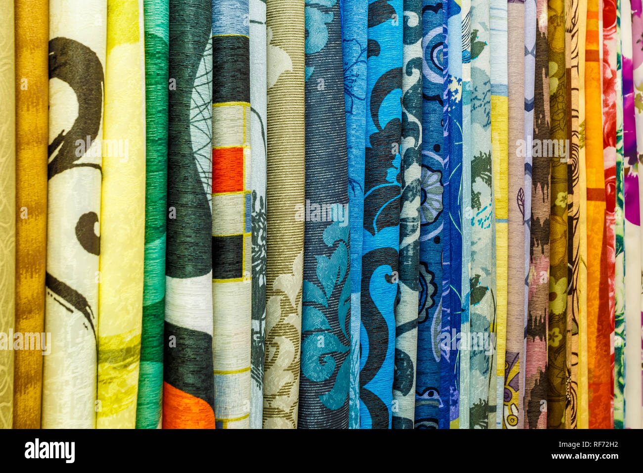 wide selection of different color textile silk fabrics clothes lay in ...