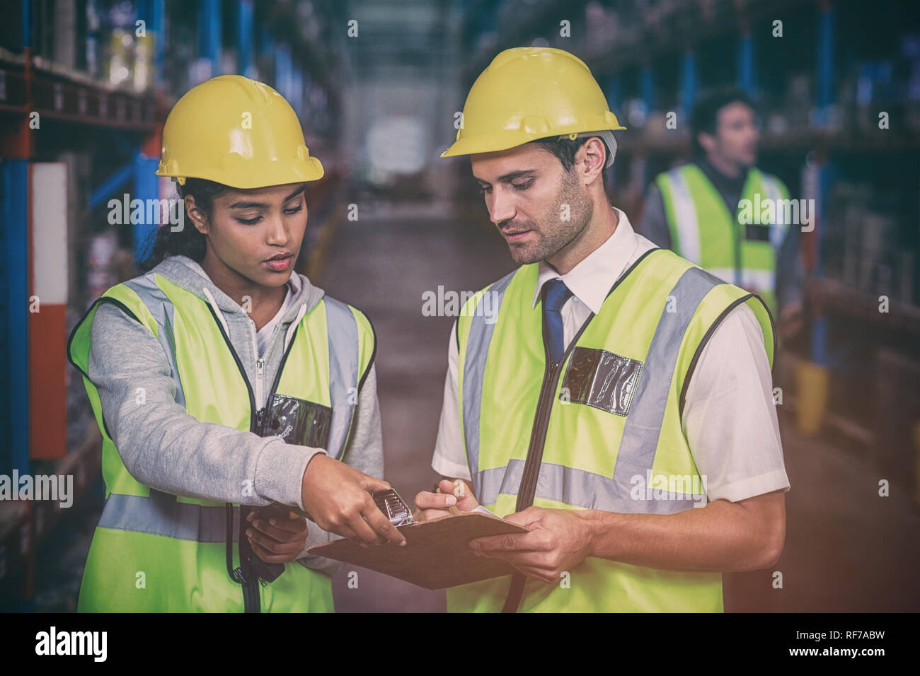 Workers looking at clipboard Stock Photo - Alamy
