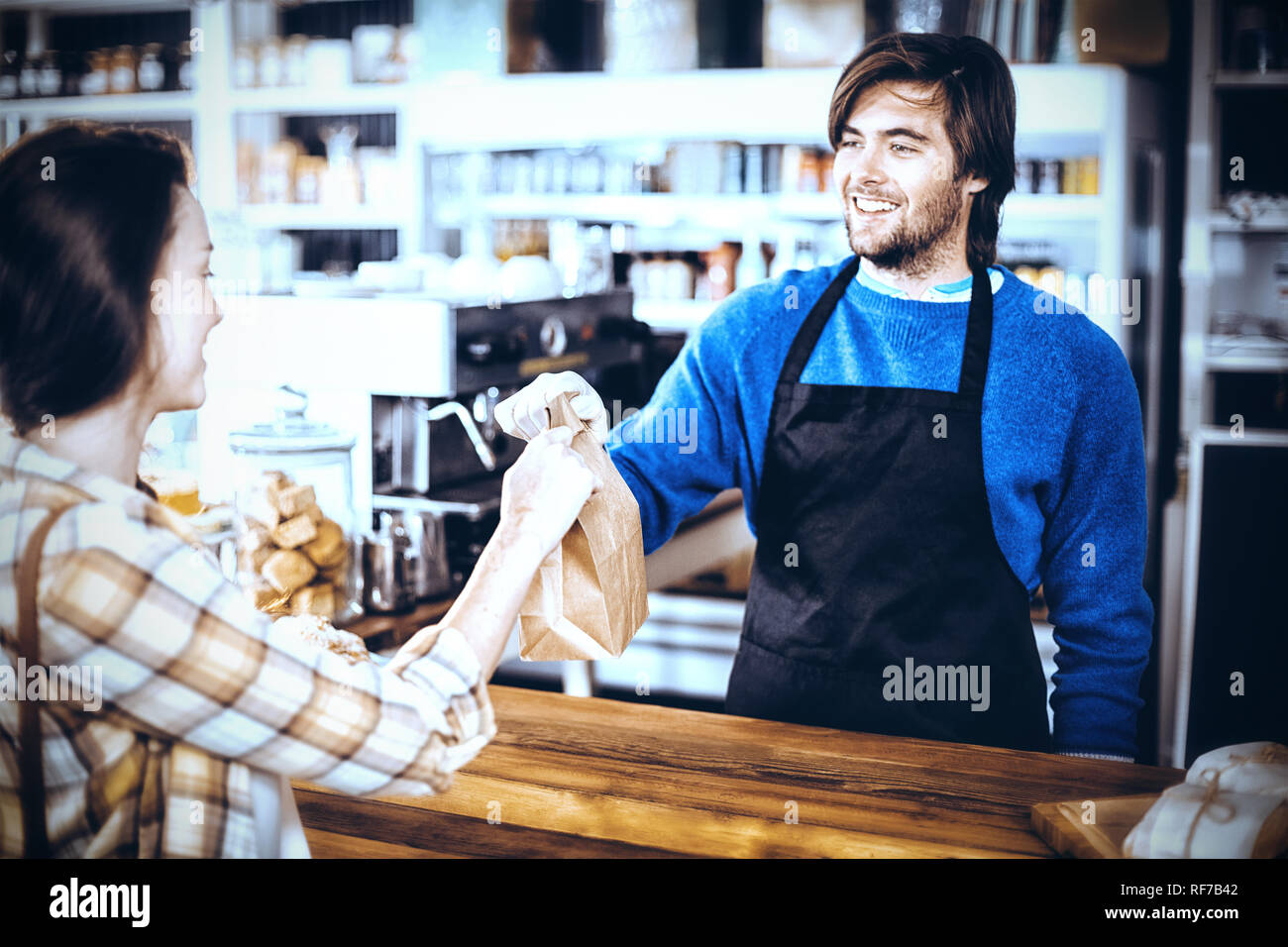 Waiter giving parcel to customer at counter Stock Photo - Alamy