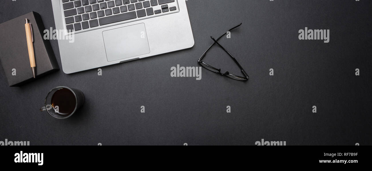 Modern workspace. Computer laptop and mobile phone on black color ...