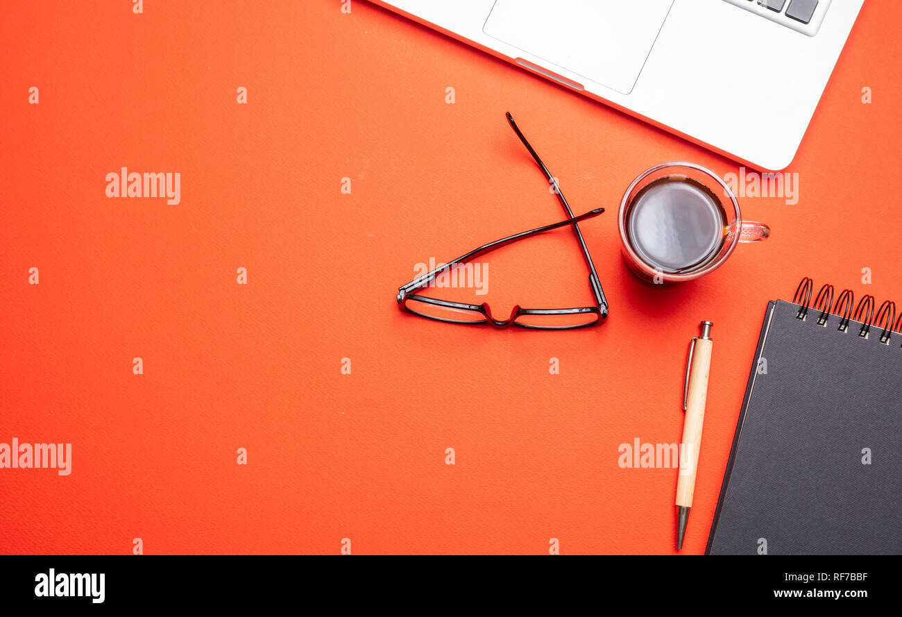 Modern workspace. Computer laptop and mobile phone on orange color ...