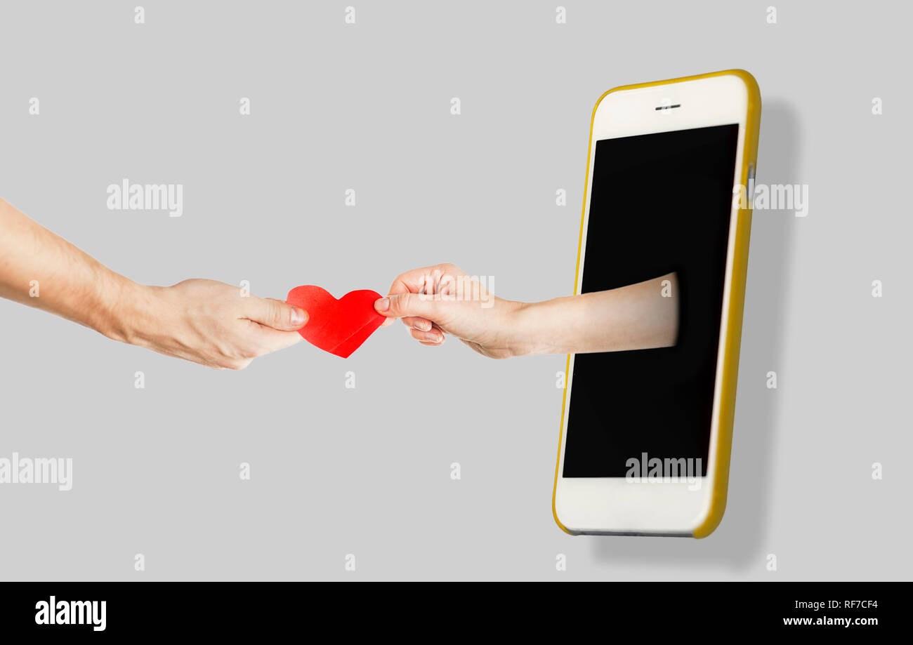 A hand holding a hand sticking out of the phone screen on an isolated ...